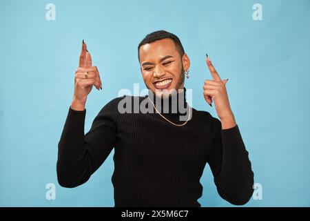 Studio portrait of smiling queer man against purple background Stock ...