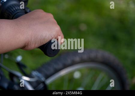 Hand of girl holding bicycle handle Stock Photo - Alamy