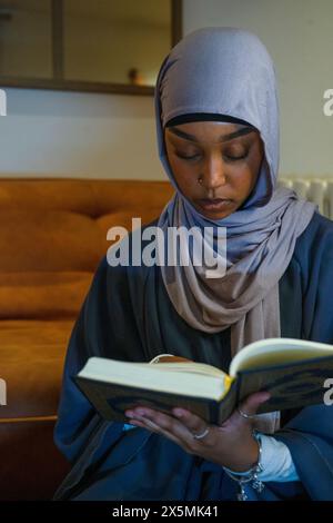 Young Muslim woman with Koran praying on yellow background Stock Photo ...