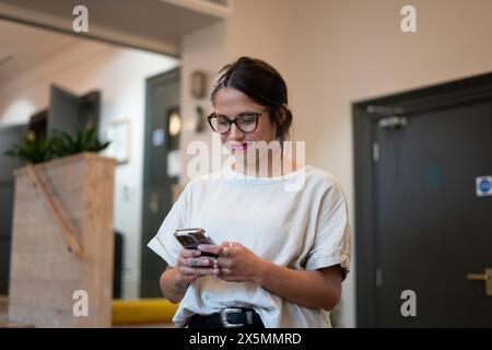 Smiling woman with tattoo using smart phone Stock Photo - Alamy