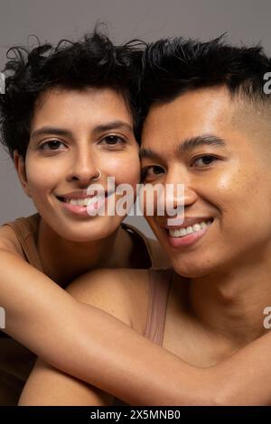 Two androgynous non binary people wearing modern clothes are walking ...