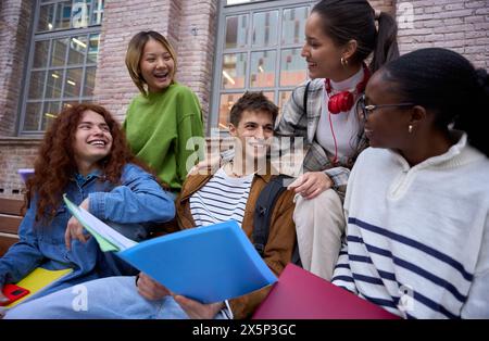 Happy group of friends studying and talking together at university ...