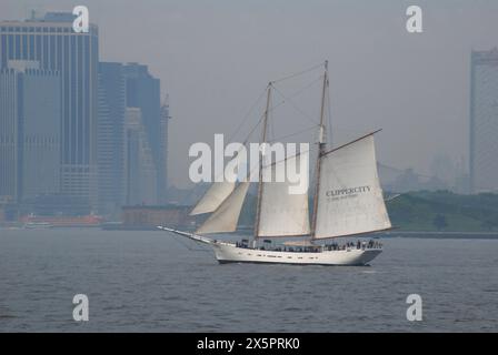 Clipper Ship tours in New York Harbor with the city skyline behind it ...