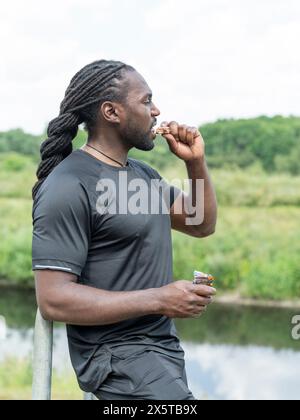 Man eating protein bar during workout Stock Photo - Alamy