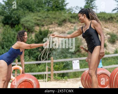 Friends building raft from barrels on beach Stock Photo - Alamy