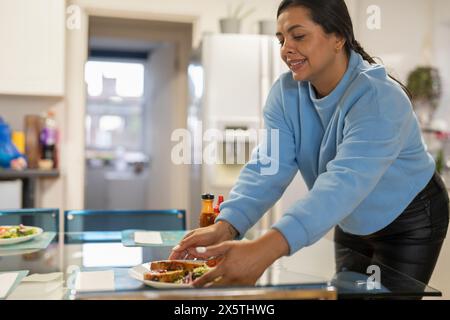 Woman bringing lunch to dining table Stock Photo - Alamy