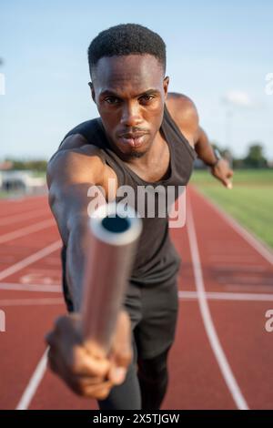 Athlete holding relay baton during race Stock Photo - Alamy