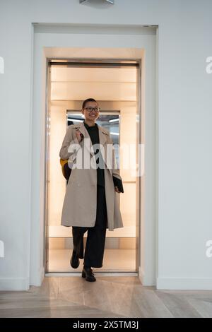 Non binary office worker walking in hallway Stock Photo - Alamy