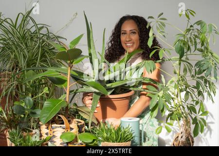 portrait of woman with green aloe leaf in front of face on light ...