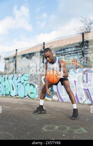 Man bouncing basketball ball on sports court Stock Photo - Alamy