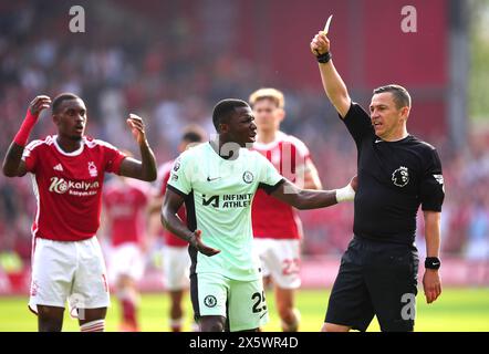 Referee Tony Harrington shows a yellow card to West Ham defender Jean ...