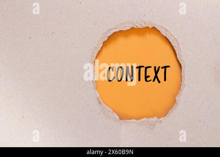 Context word written on ripped yellow paper with blue background ...