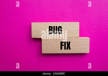 Bug fix words written on wooden blocks with red background. Conceptual ...