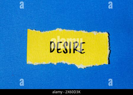 Desire word written on ripped paper piece with brown background ...