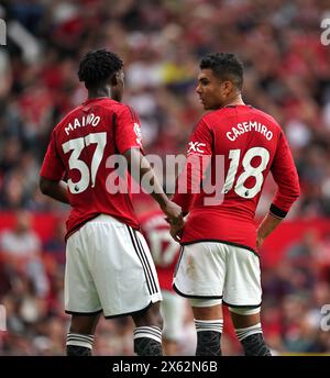 Manchester United's Kobbie Mainoo, left, fights for the ball with ...