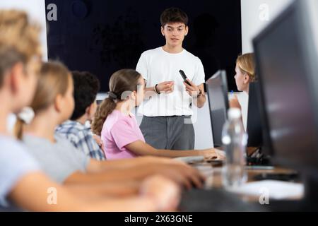 Guy teacher teaches group of students in computer class Stock Photo - Alamy
