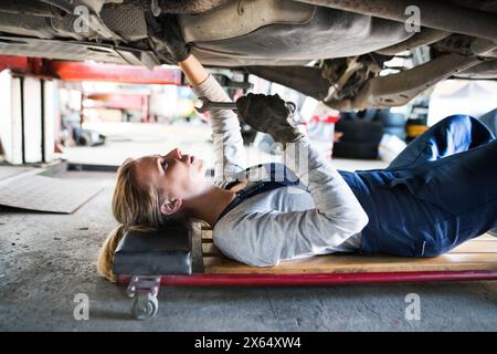 Female auto mechanic repairing, maintaining car. Beautiful woman ...