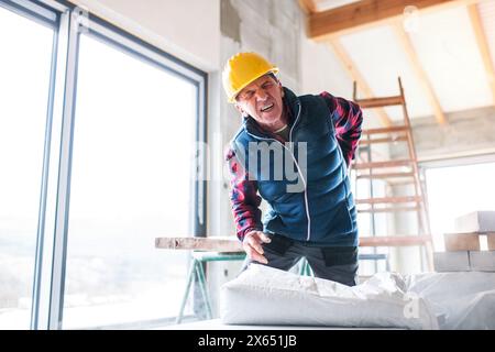 Older worker feeling pain in back after carrying heavy bag. Work ...