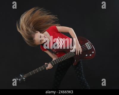enthusiastic girl playing bass guitar Stock Photo - Alamy