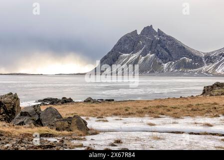The Eystrahorn (Batman Mountain) in winter behind an icy bay in south ...