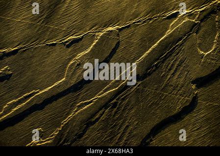 A close up of a rock with a goldish tint. The rock has a rough texture ...