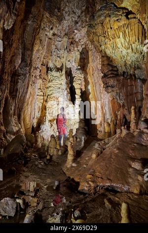 Speleologist in a cave, column, stalagmites and stalactites, stalagnate ...