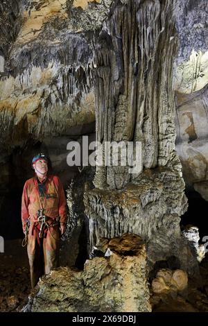 Speleologist in a cave, column, stalagmites and stalactites, stone ...