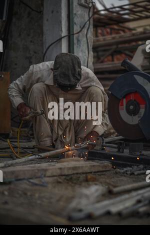 Poor old skilled Pakistani Welder welding pipes and metal rods in his ...