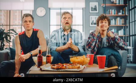 At Home Three Joyful Basketball Fans Sitting on a Couch Watch Game on ...
