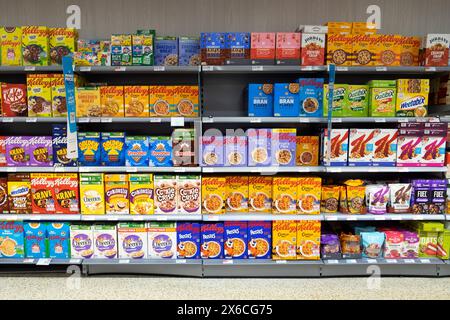 Rows of boxes of various brands of breakfast cereal on shelves in Co Op ...