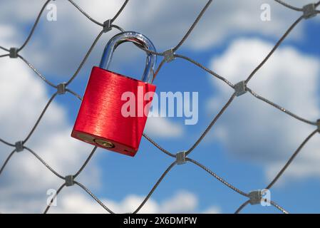 A romantic red heart lock on an urban industrial bridge railing ...