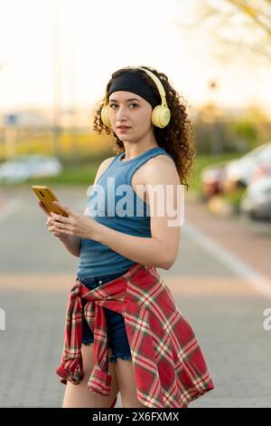 Woman with headphones standing on blue background Stock Photo - Alamy