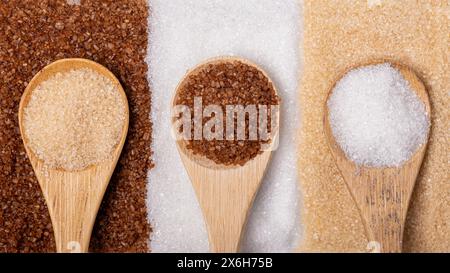 Various types of sugar in bamboo spoons, wholemeal, white and liquorice ...