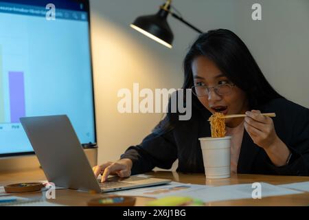 The woman ate instant noodles while working late at the office Stock ...