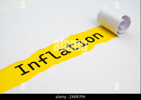 Yellow surface, with the word Inflation in black, underneath torn and ...