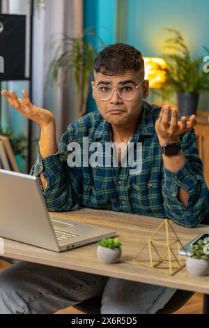 Young hispanic man at the office clueless and confused expression with ...