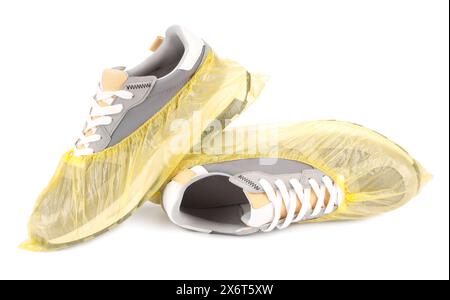 Men's sneakers in yellow shoe covers isolated on white Stock Photo - Alamy