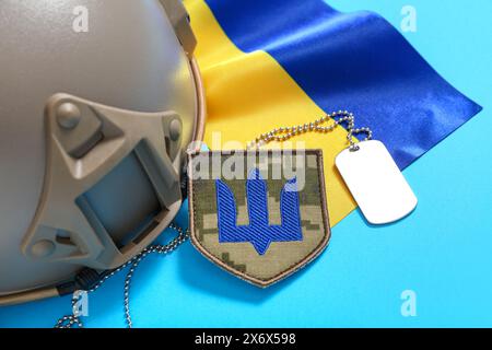 Military badge with trident, tactical helmet and flag of Ukraine on ...