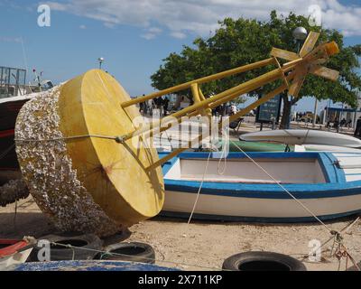 Small pleasure craft with yellow concrete land marker buoy in the ...