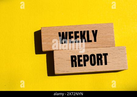 Weekly report words written on wooden blocks with yellow background ...