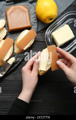 Making sandwich with quince paste. Woman buttering bread at wooden ...