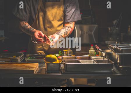 Chef with tattoos workinng in an open fire open kitchen in Singapore ...