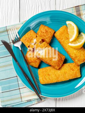 crispy fried battered alaskan pollock fillet on blue dish with lemon ...