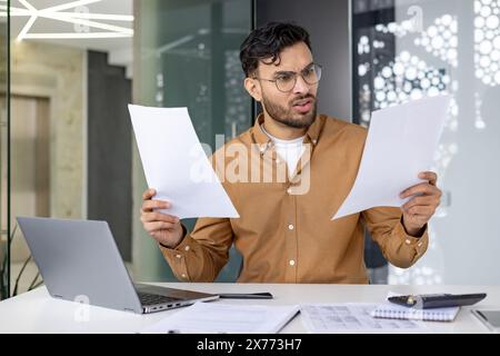 Young man in office reviewing documents Stock Photo - Alamy