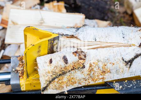 Mechanical action of a wood splitter with destructive force on a birch ...