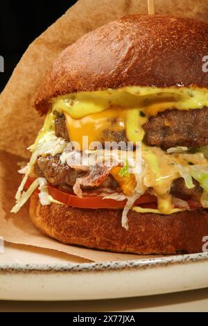Double hamburger with beef patties in paper wrapper on plate Stock ...