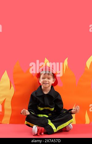 Cute little firefighter sitting on orange background Stock Photo - Alamy