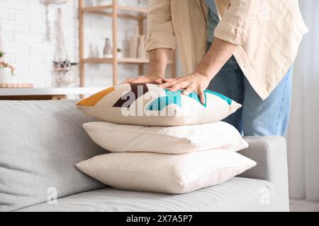 Young man adjusting sofa cushions at home Stock Photo - Alamy