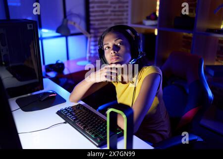 African american woman streamer sitting on table with serious ...