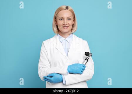 Happy dermatologist with dermatoscope on light blue background, space ...